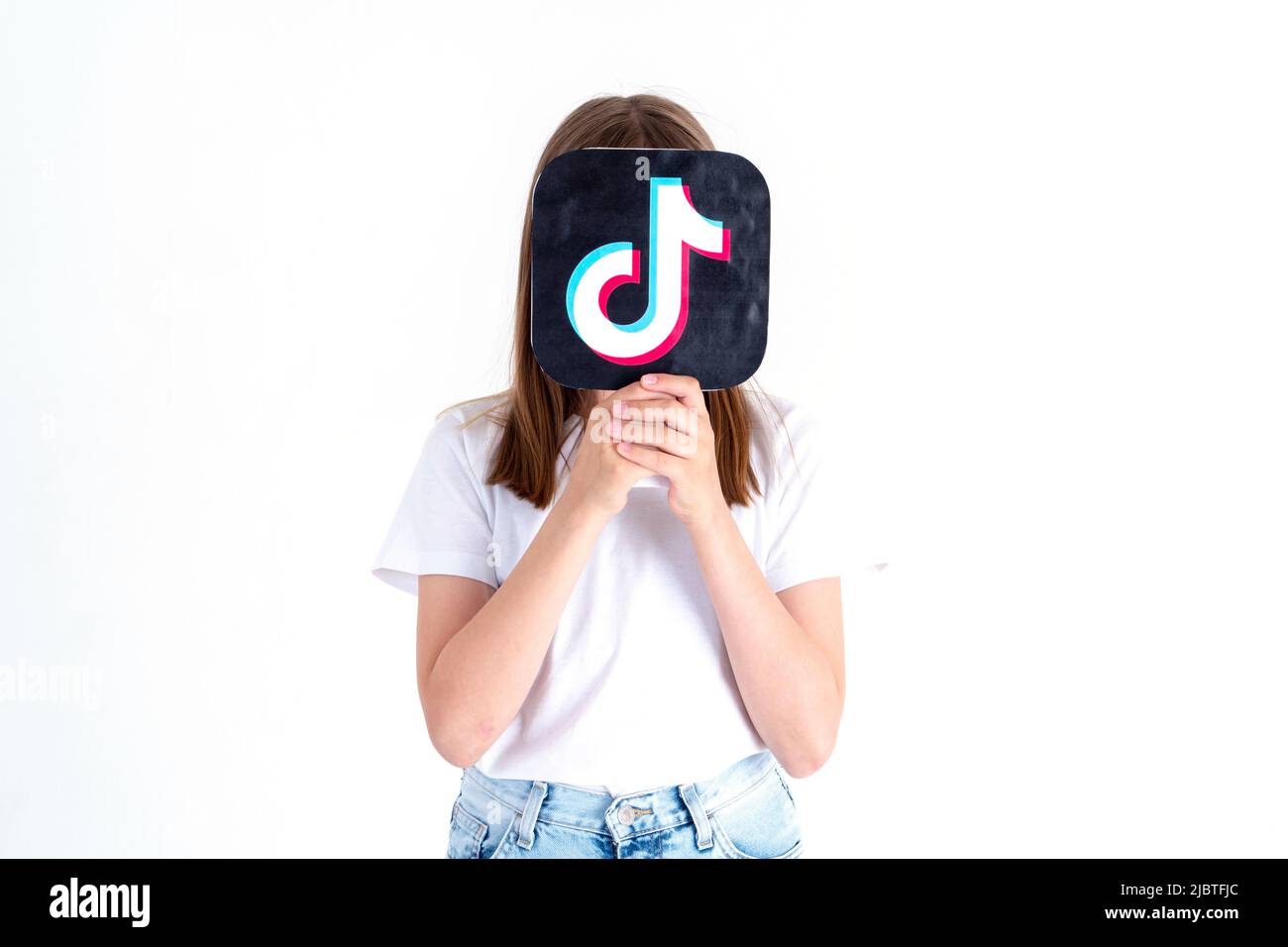 caucasian teenager holding a tiktok logo picture in his hands on a ...