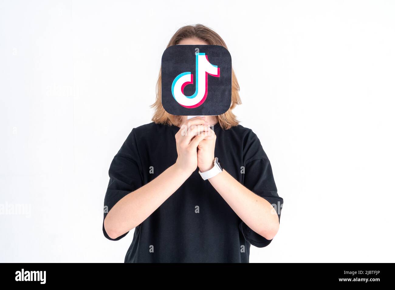 caucasian teenager holding a tiktok logo picture in his hands on a ...