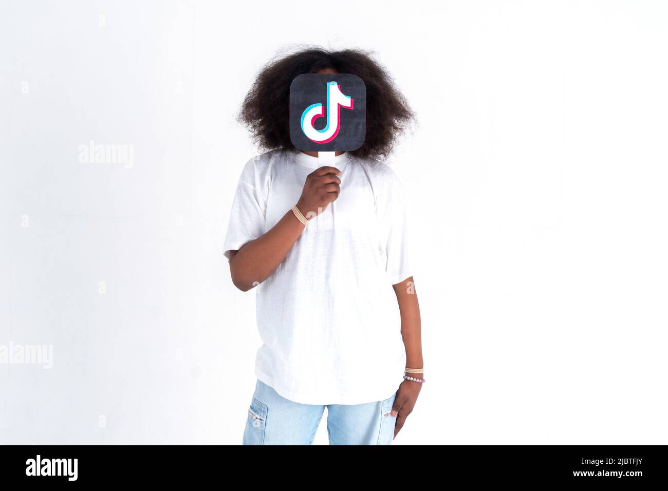 African american teenager holding a Tiktok logo picture in his hands on ...
