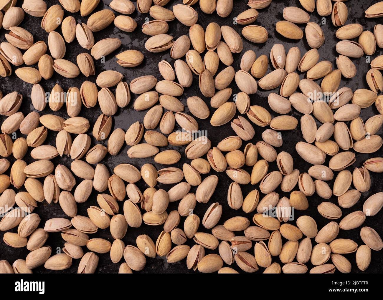 tasty pistachios shell nuts on black background, top view, organic ...