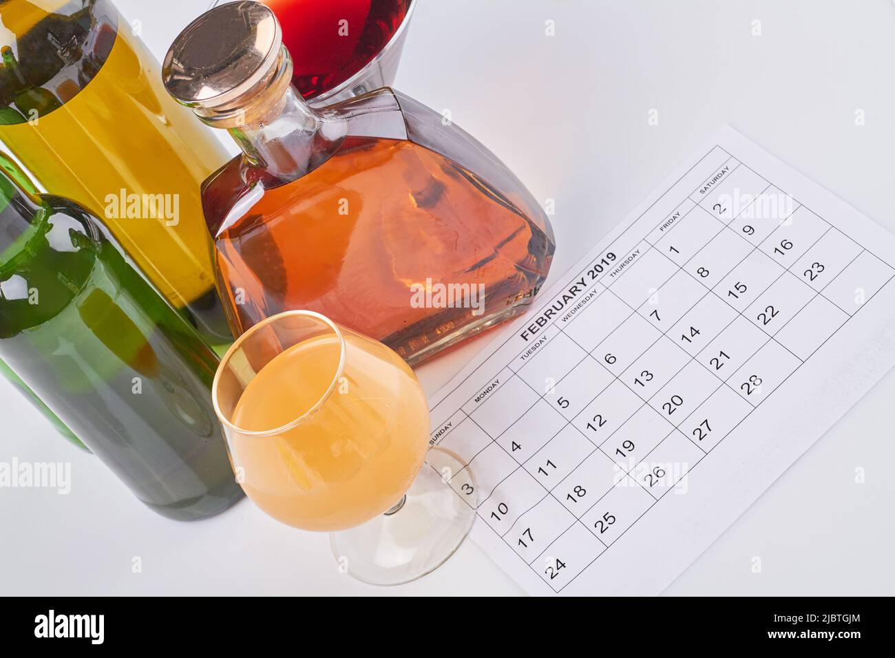 Set of various alcoholic drinks and calendar on white background ...
