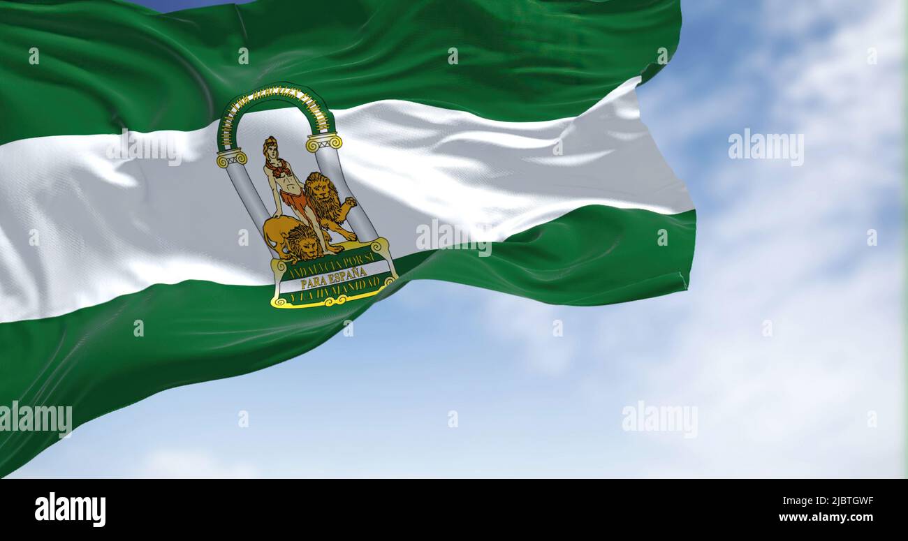 Andalusian flag waving in the wind on a clear day. Andalusia is the ...