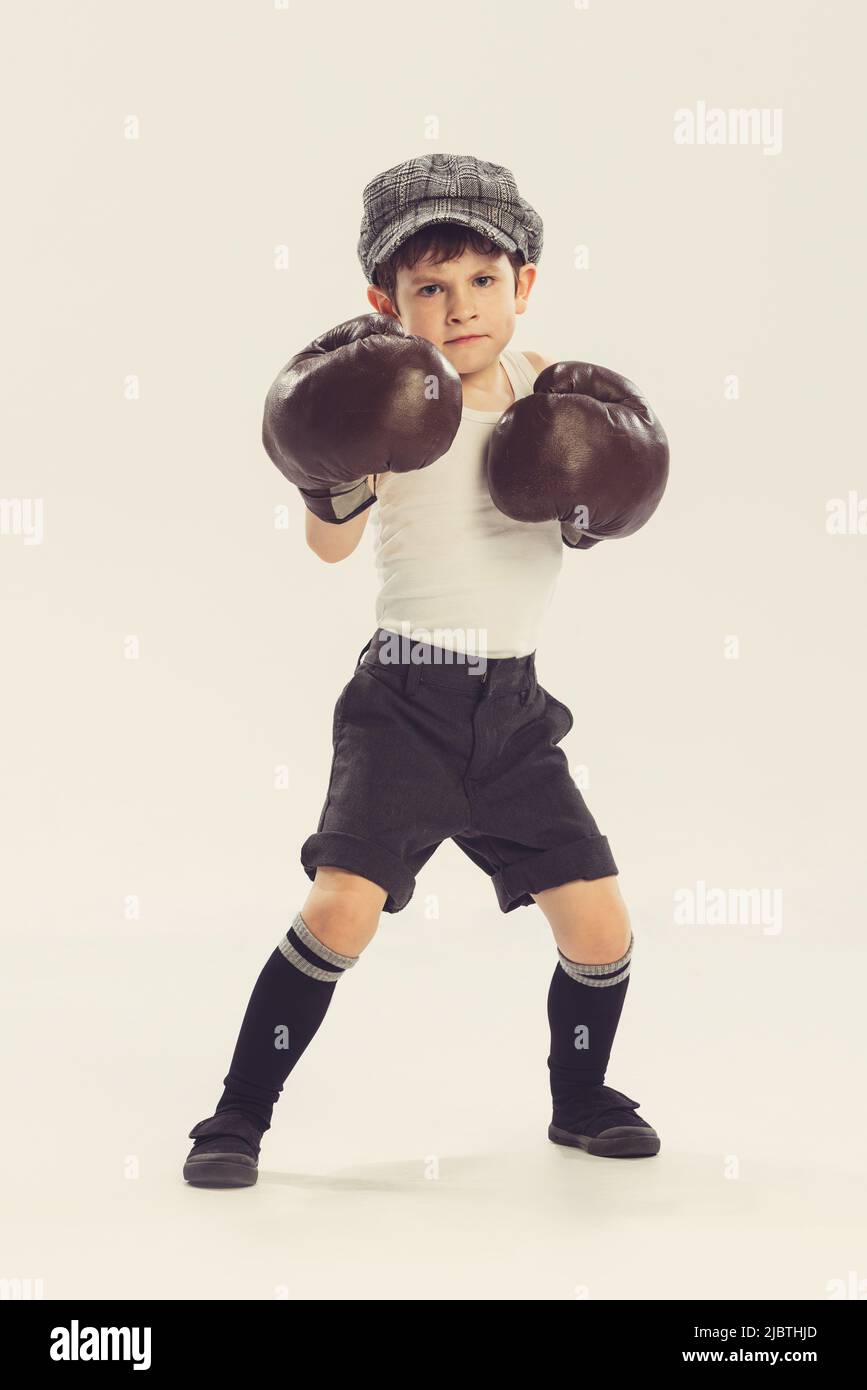 Portrait of little boy, child in giant boxing gloves posing, playing ...