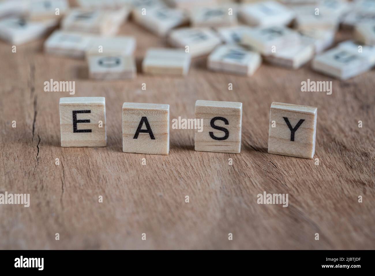 the word easy written with cube letters on wooden background Stock ...