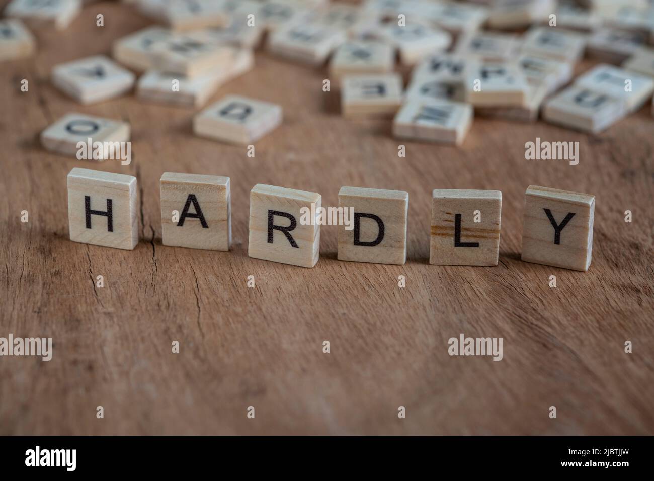 the word hardly written with cube letters on wooden background Stock ...