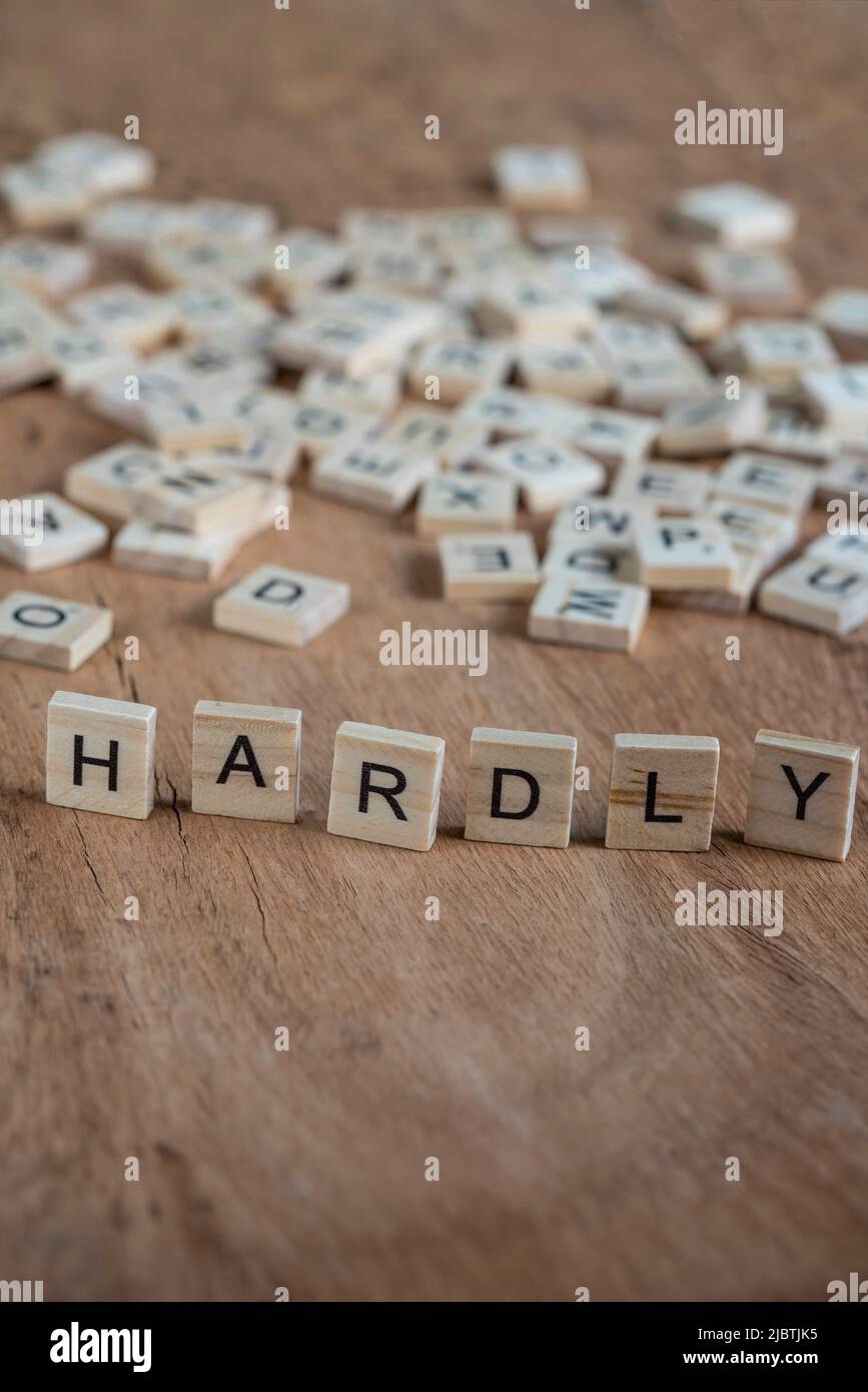the word hardly written with cube letters on wooden background Stock ...