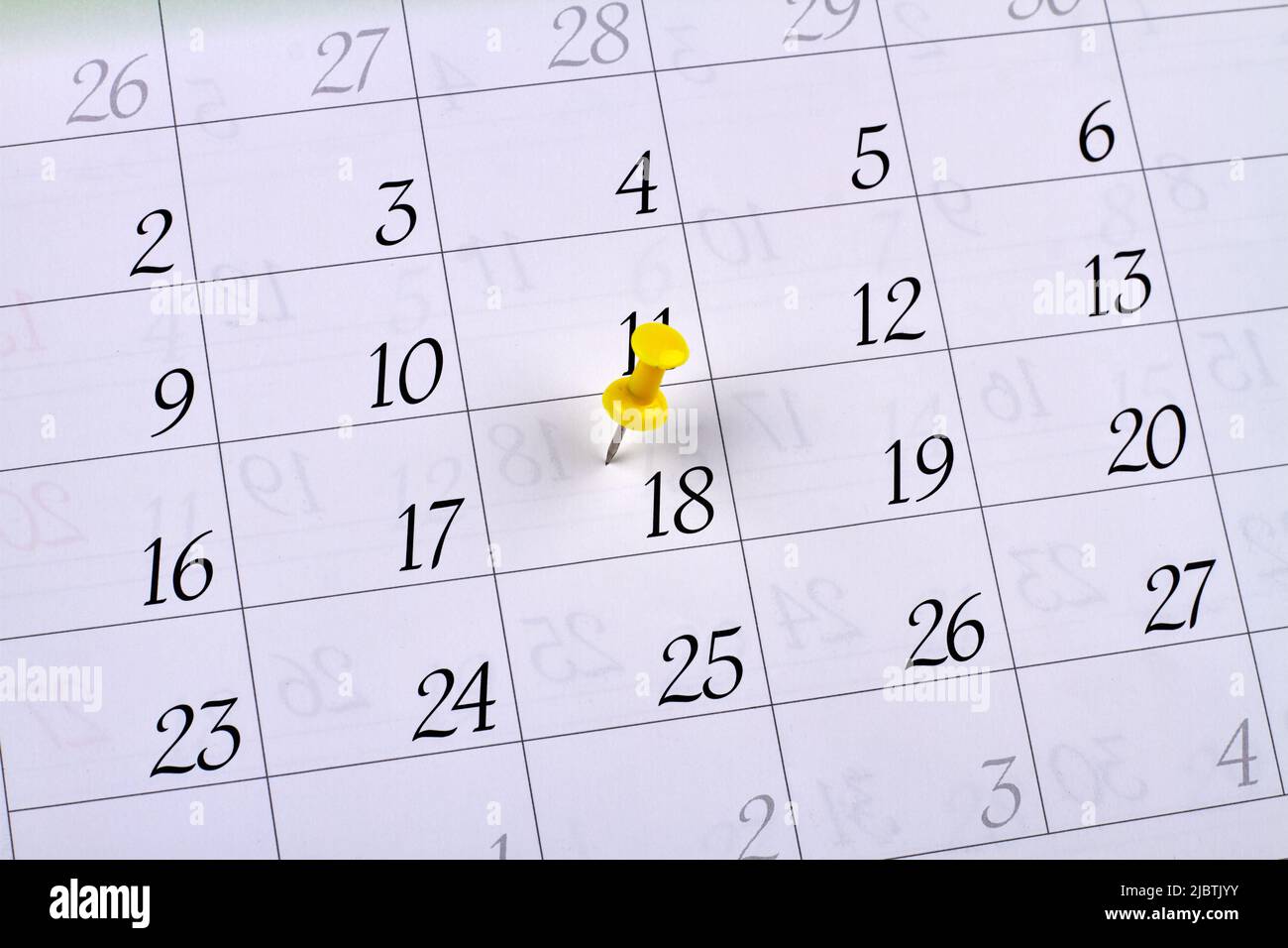 Yellow push pin on the 18th day of a calendar. Marked event or holiday ...