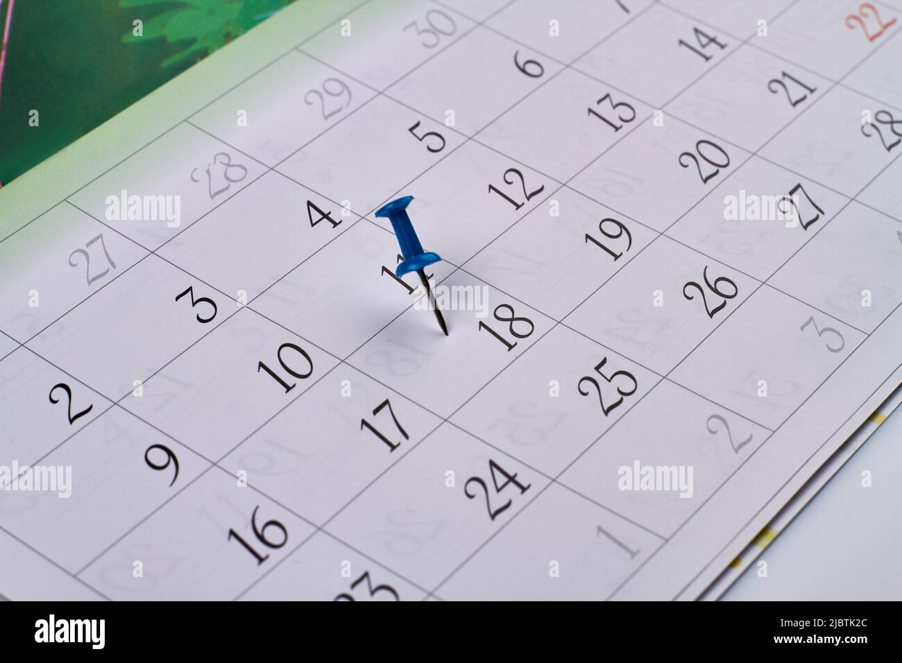 Close-up blue push pin on the month calendar. Mark 18th day of month ...