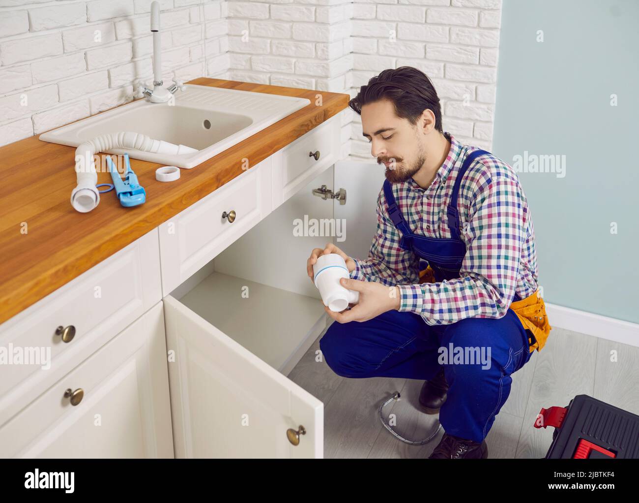 Male plumber work in kitchen in client home Stock Photo - Alamy