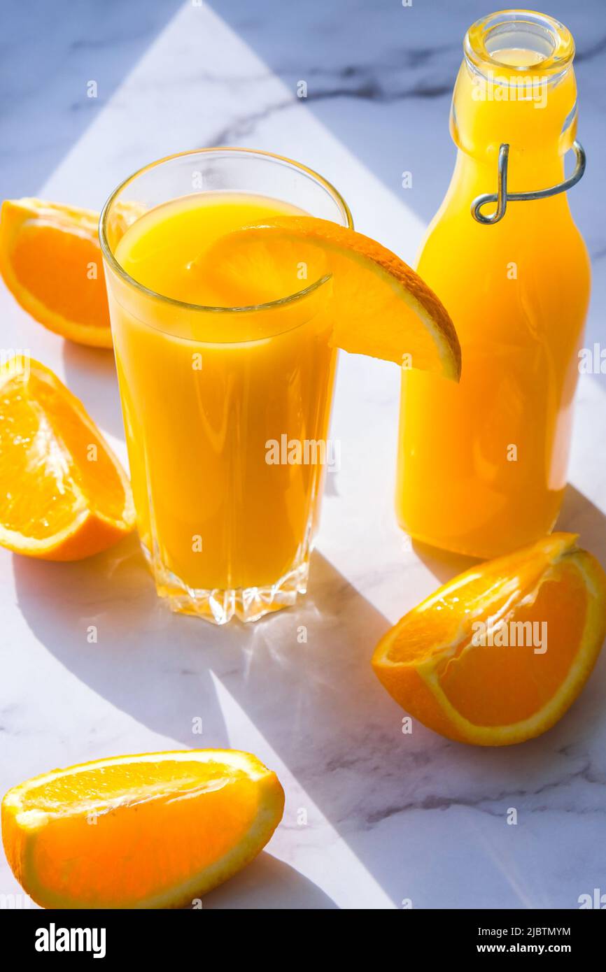 Glass bottle of fresh squeezing Orange juice with sliced fruits on ...