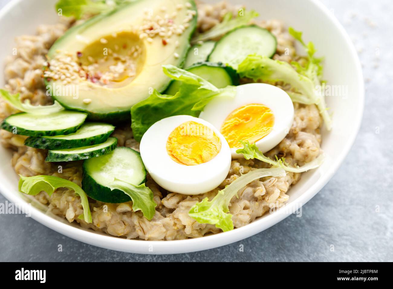 Oatmeal porridge with boiled egg, cucumber and avocado Stock Photo - Alamy