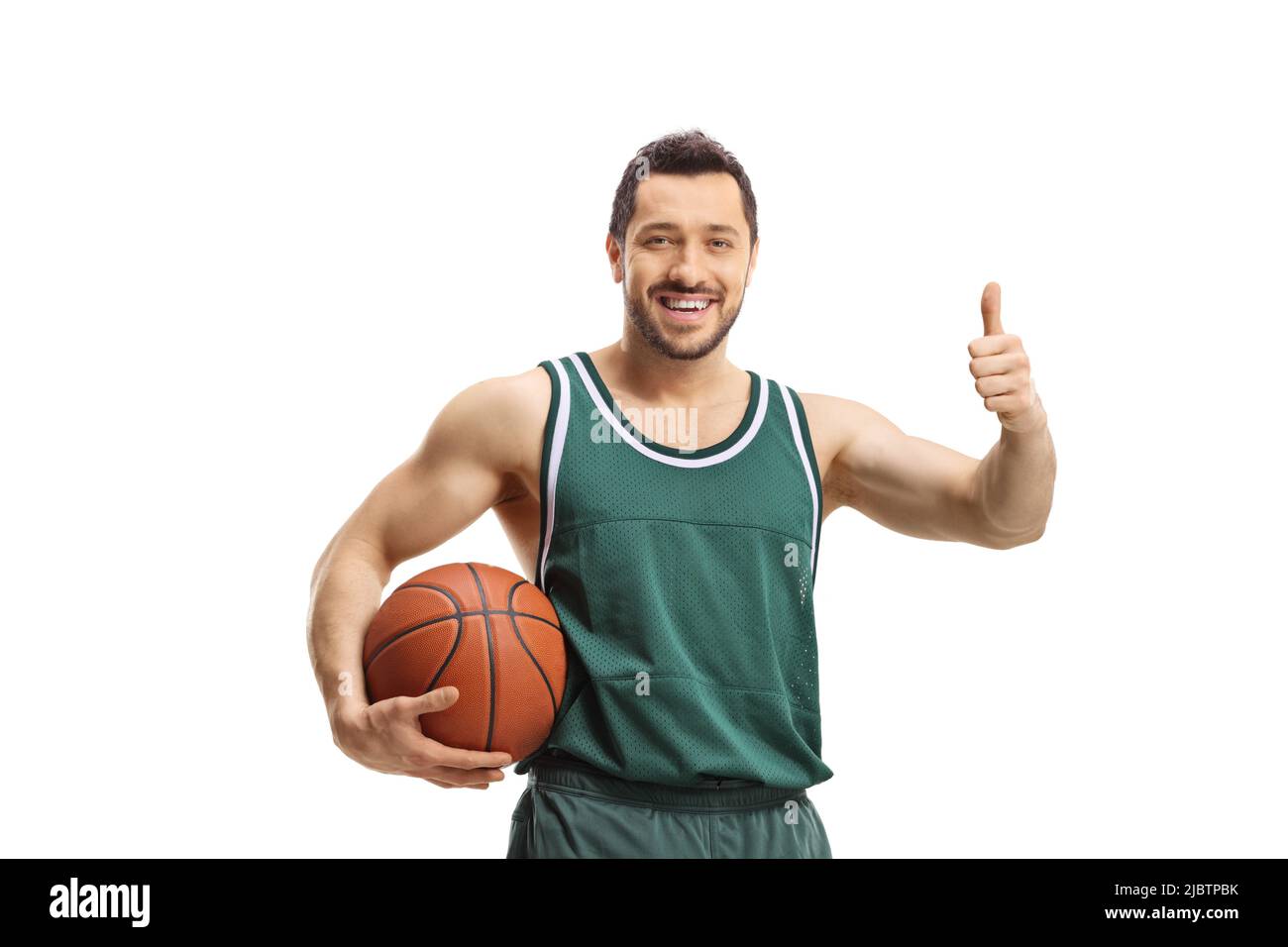 Smiling basketball player holding a ball and showing thumbs up isolated ...