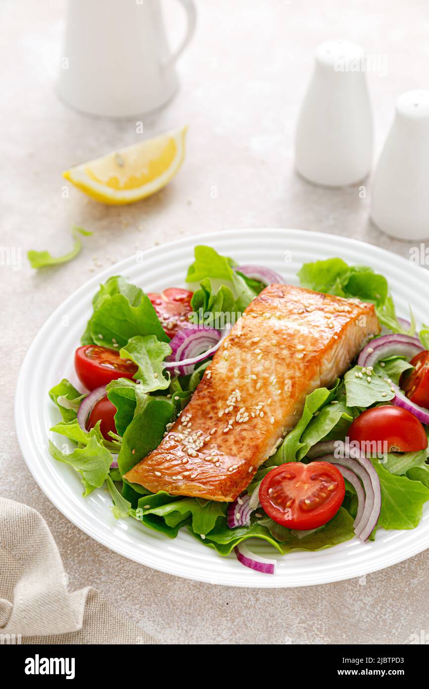 Grilled salmon fish fillet and fresh vegetable salad with tomato, red ...