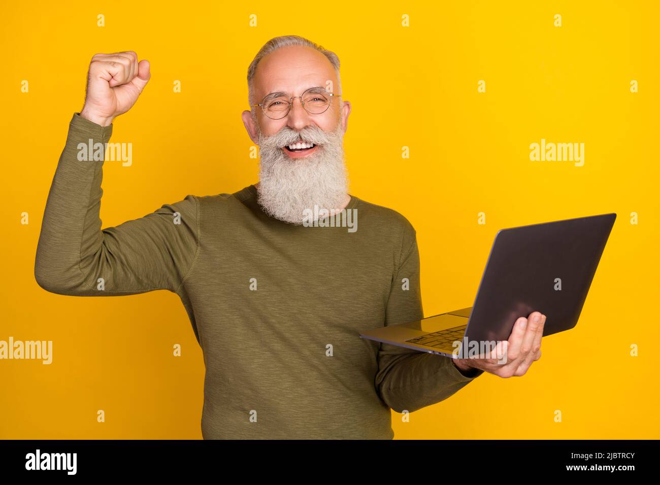 Photo of hooray elder grey beard man hold laptop hand fist wear eyewear ...