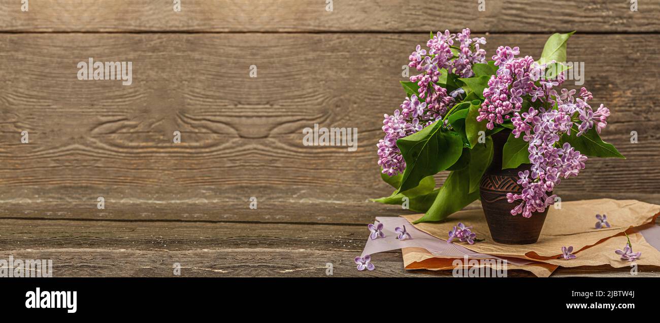Lilac flowers bouquet with green leaves in a ceramic vase. Nature ...