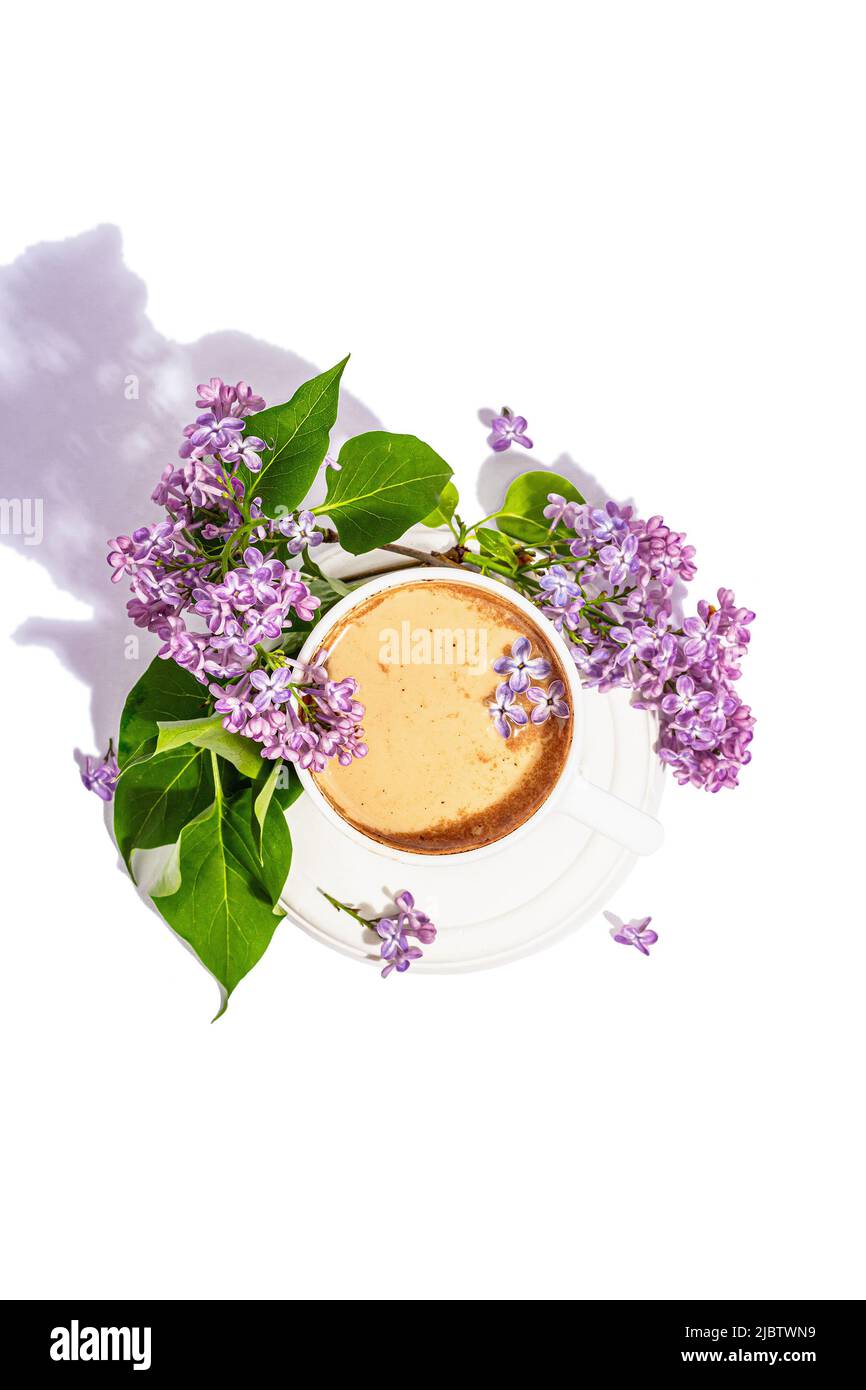 Cup of coffee and lilac flowers bouquet isolated on a white background ...