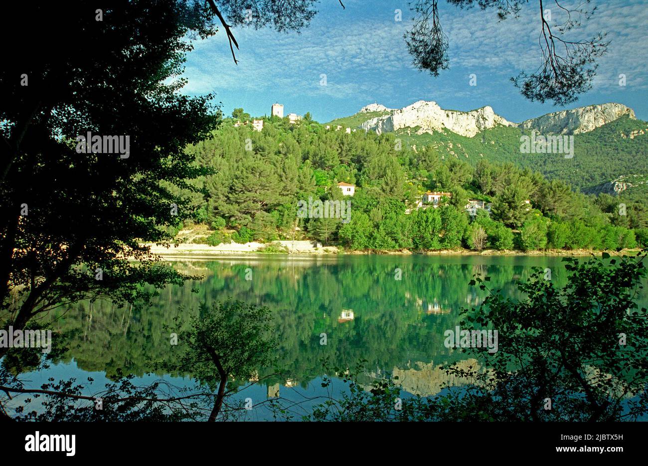 Reflection of the village of Revest les Eaux in the reservoir dam lake ...