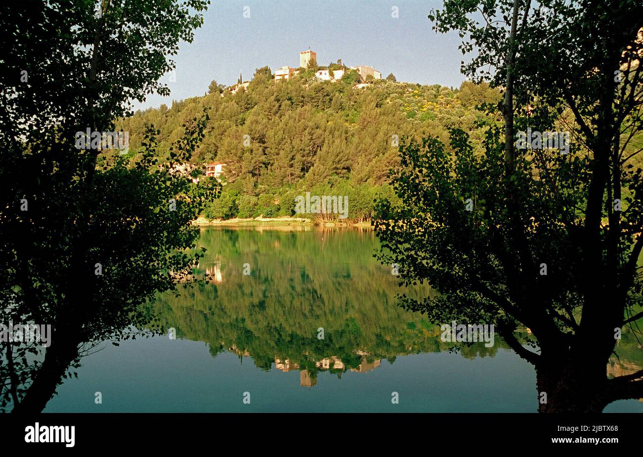 Reflection of the village of Revest les Eaux in the reservoir dam lake ...