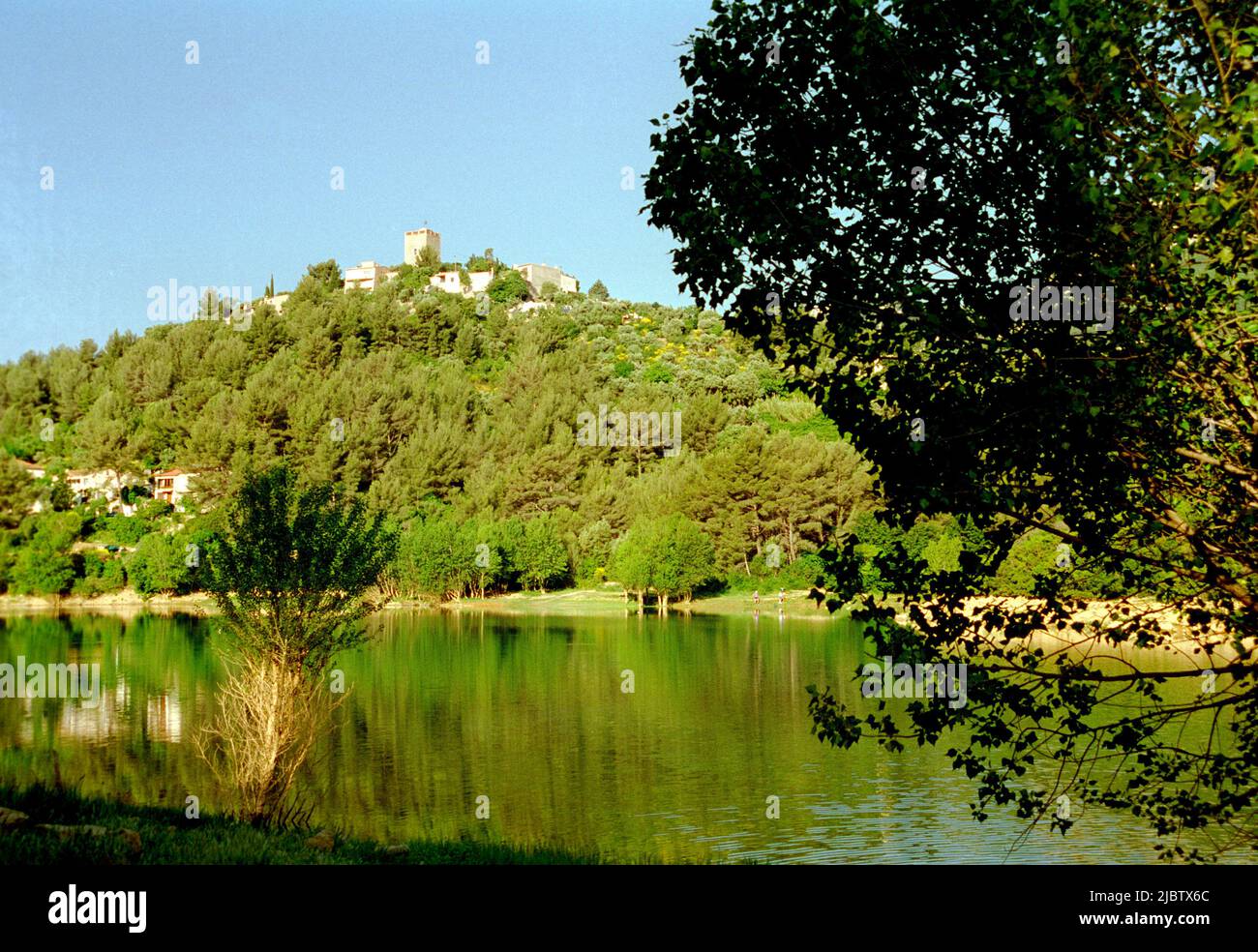 Reflection of the village of Revest les Eaux in the reservoir dam lake ...