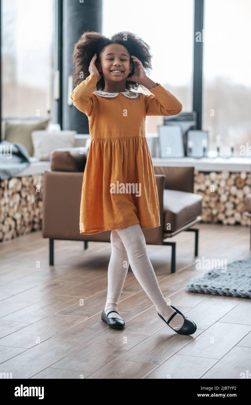Cute curly-haired girl looking cheerful and happy Stock Photo - Alamy Cute curly-haired girl looking cheerful and happy Stock Photo - Alamy