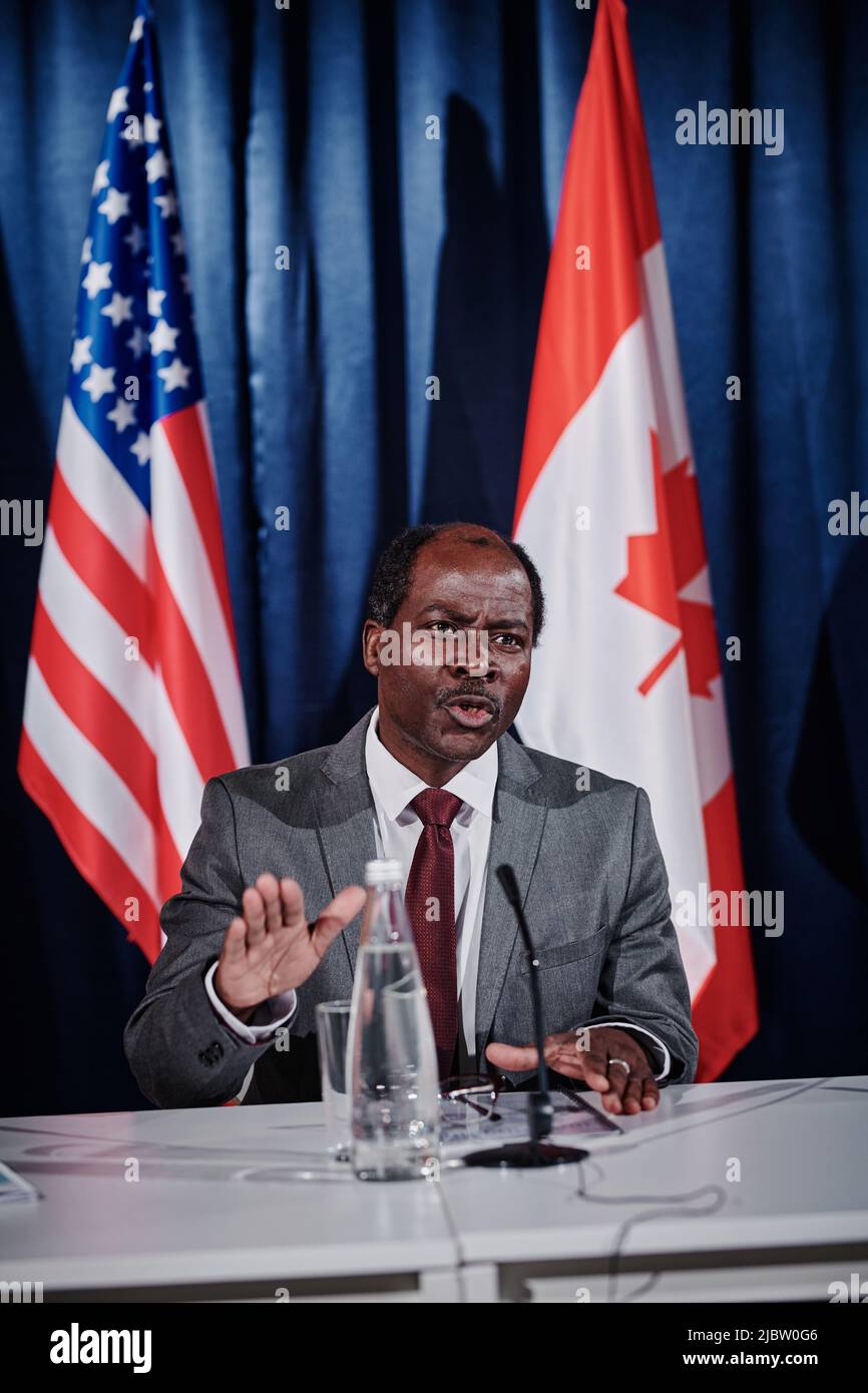 African American politician in suit sitting at table and talking about ...