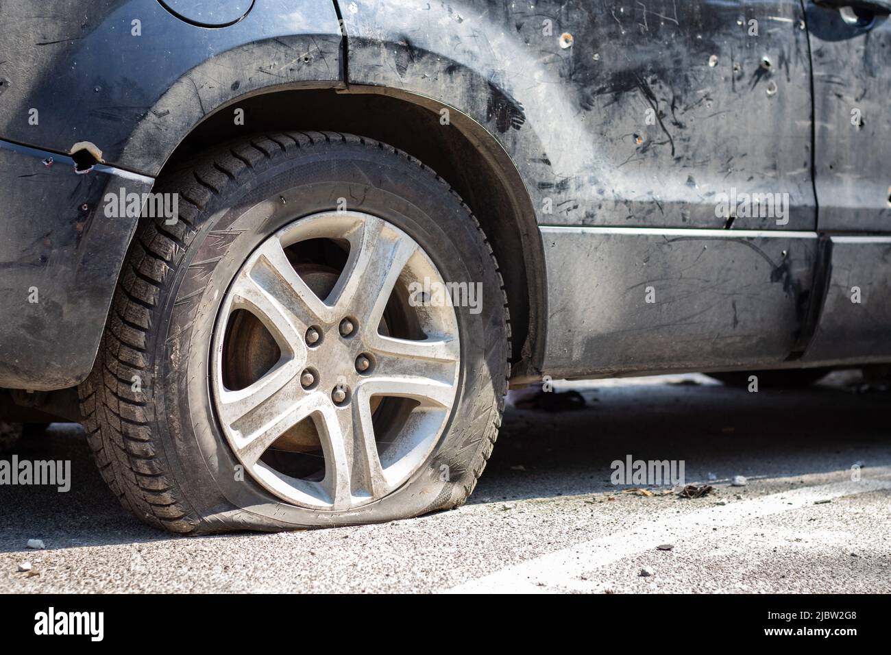 Shot car during the war in Ukraine. A car of civilians with shrapnel ...