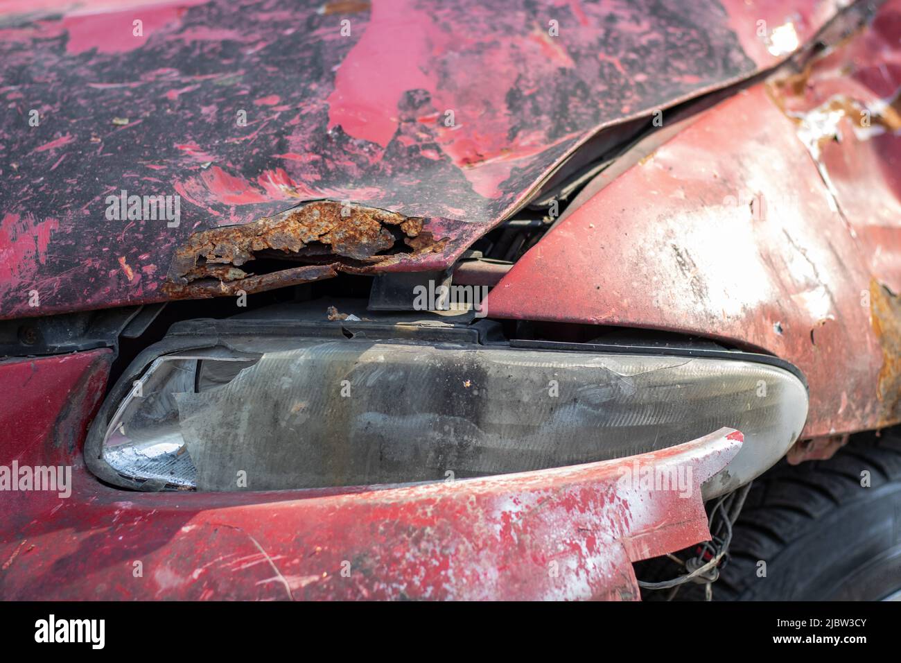 Broken headlights as a result of a collision. Broken red car after an accident. Car accident ...
