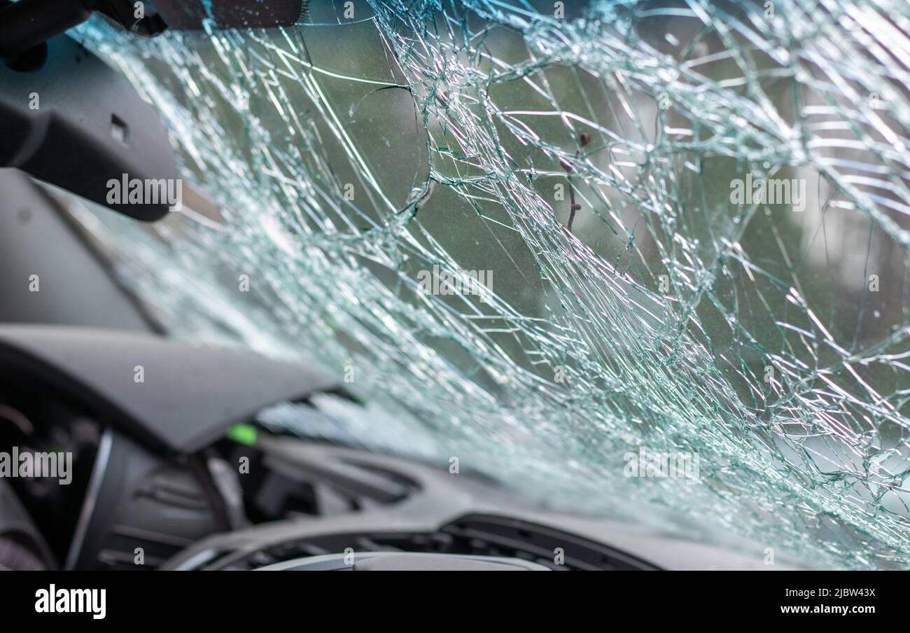 Damaged car window after an accident. Broken windshield as a result of ...