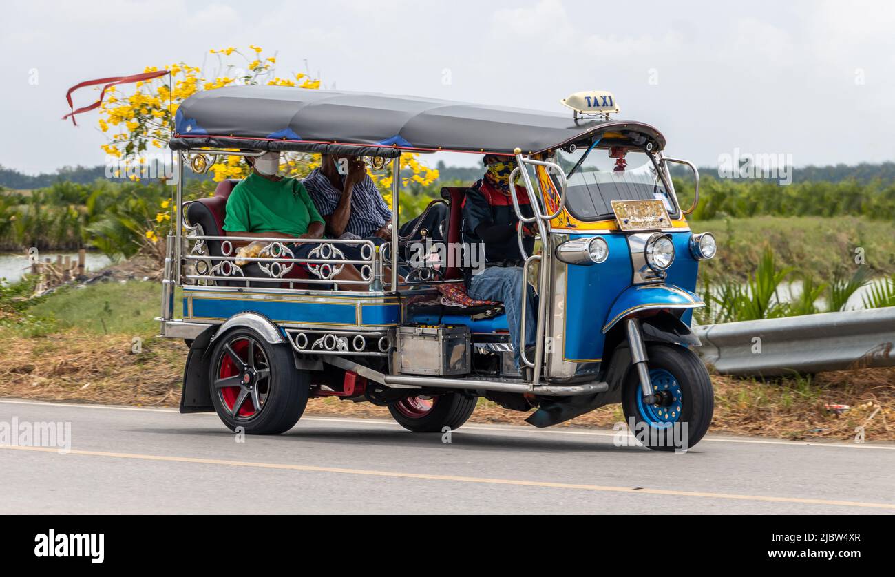 A traditional motor tricycle - tuk tuk rides on a rural road,Thailand ...