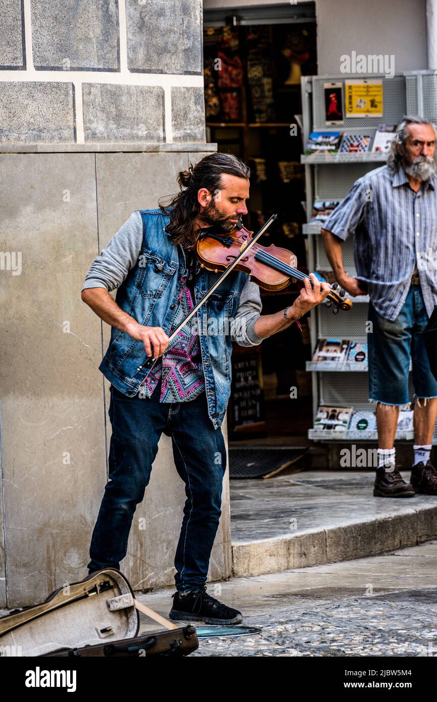 Granada, Spain -- June 5, 2022. A busker plays the violin on a street ...