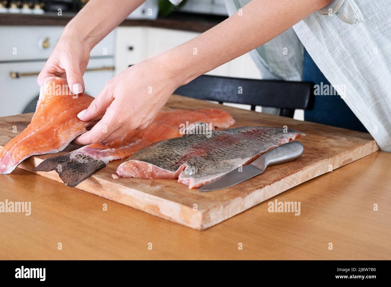 Female hands cutting fillet of red fish. Red caviar. Removing fish ...