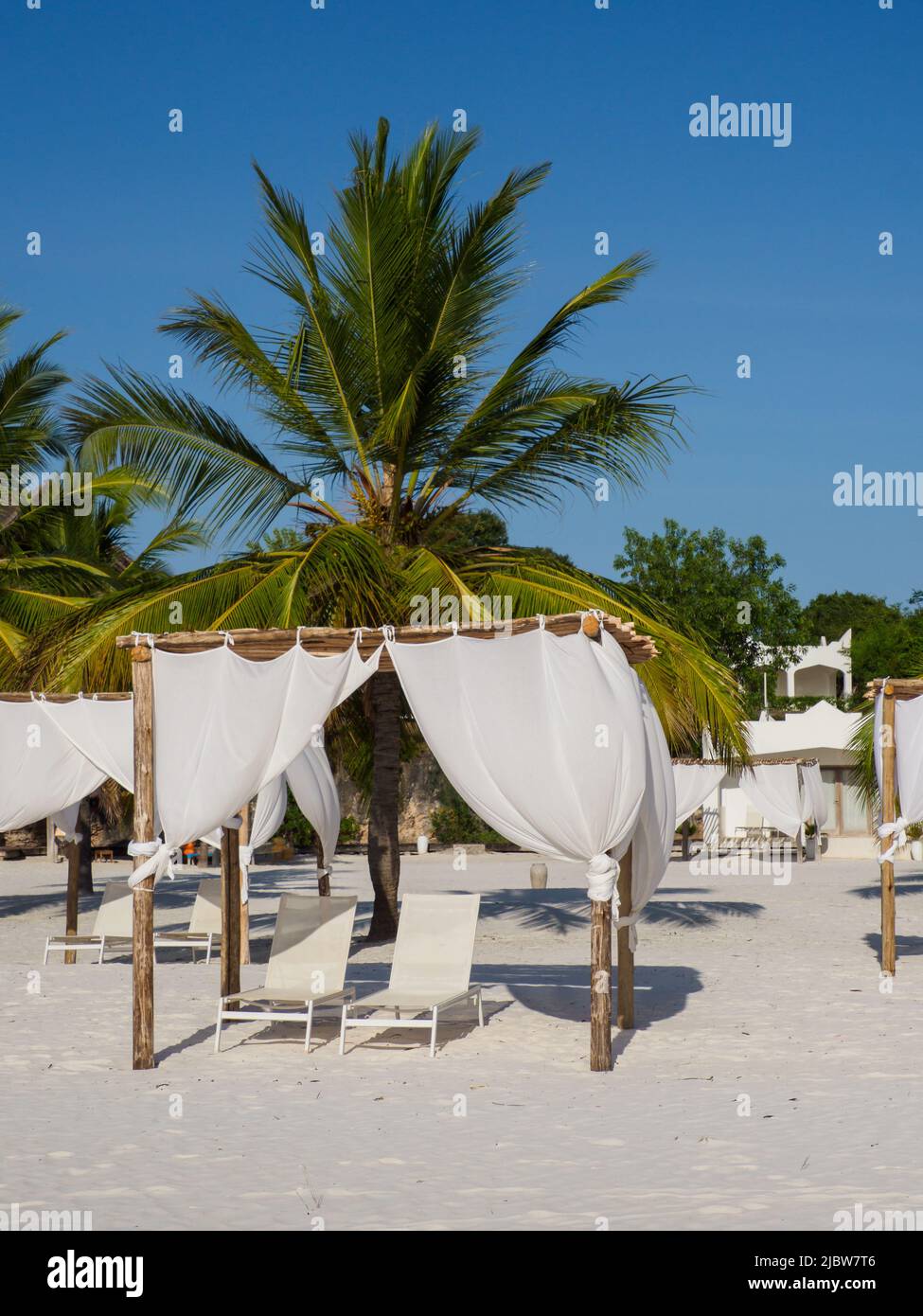 Sun loungers covered with white, airy curtains in a luxurious resort by ...