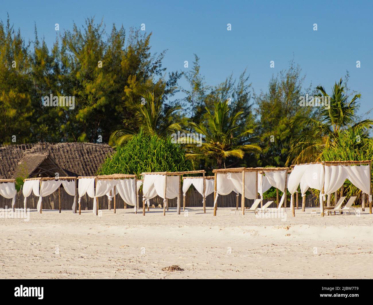 Sun loungers covered with white, airy curtains in a luxurious resort by ...