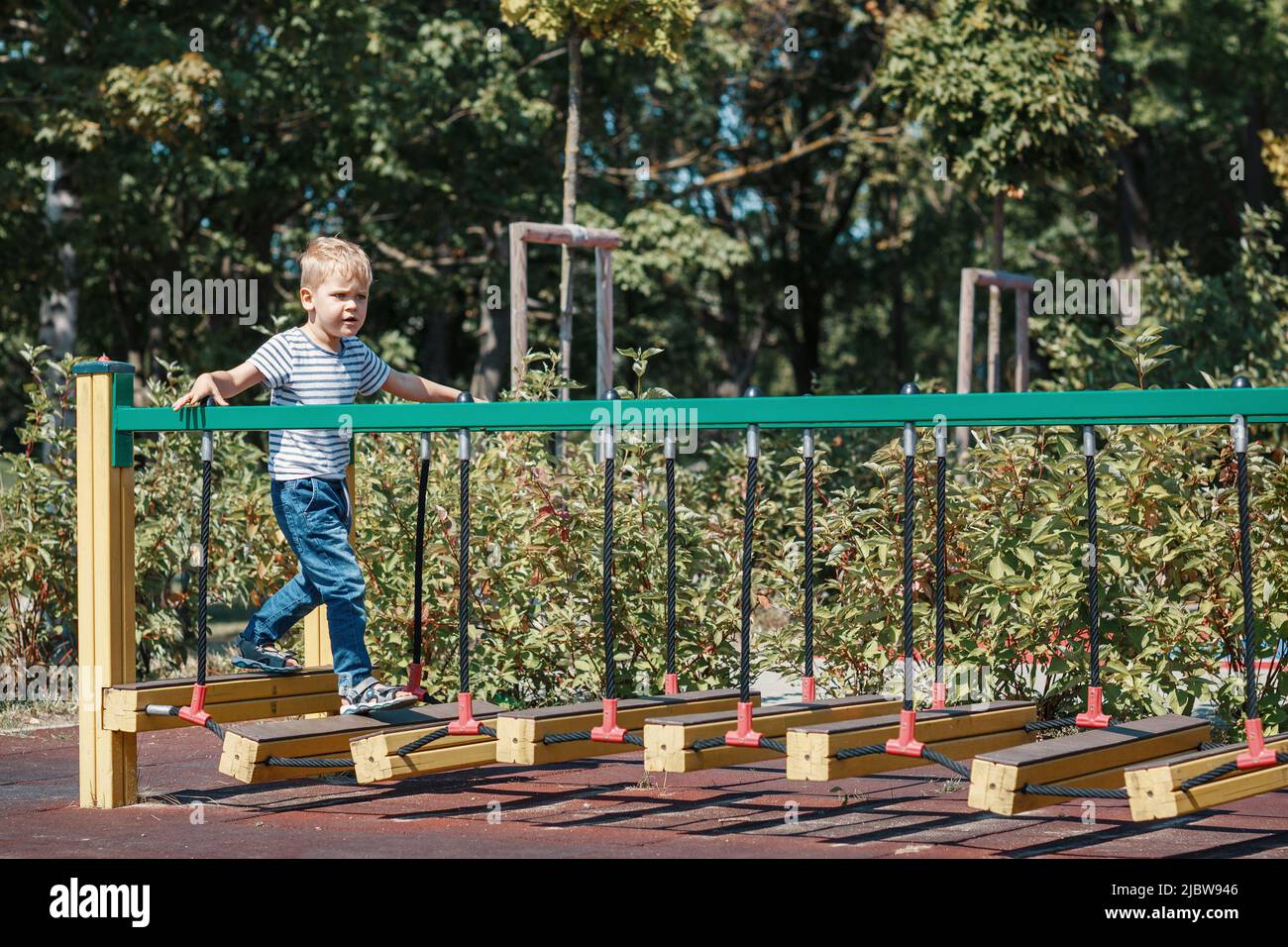 A brave little boy goes across the bridge of the monkeys in a city ...