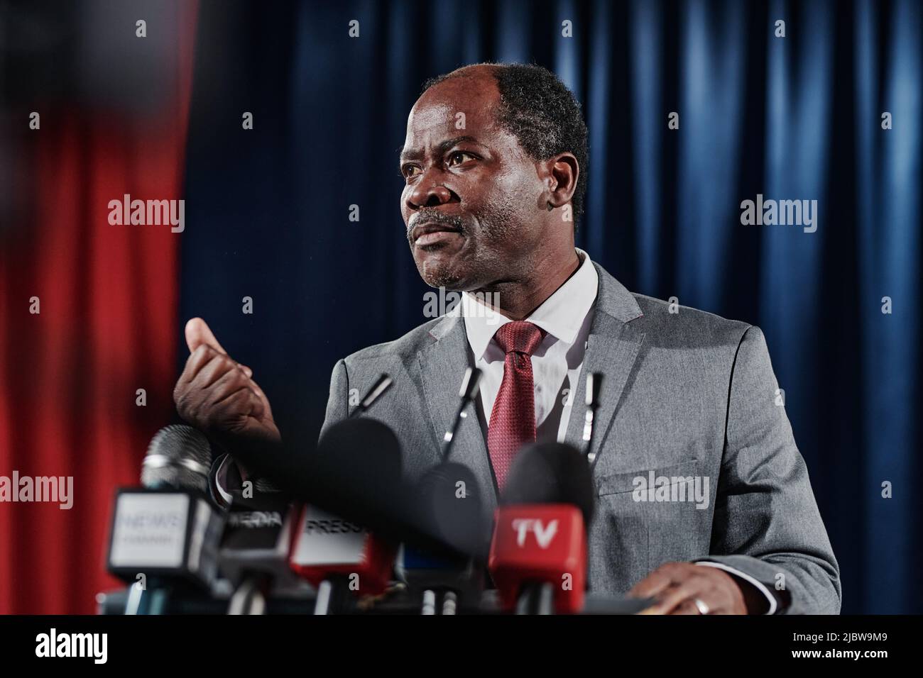 African American mature businessman in suit speaking behind the podium ...