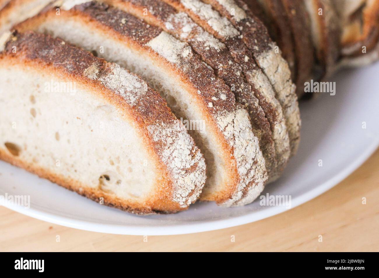 Sourdough bread slices on a white platter Stock Photo - Alamy