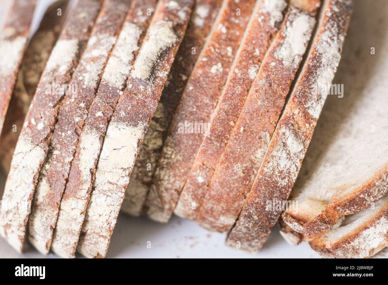 Sourdough bread slices on a white platter Stock Photo - Alamy