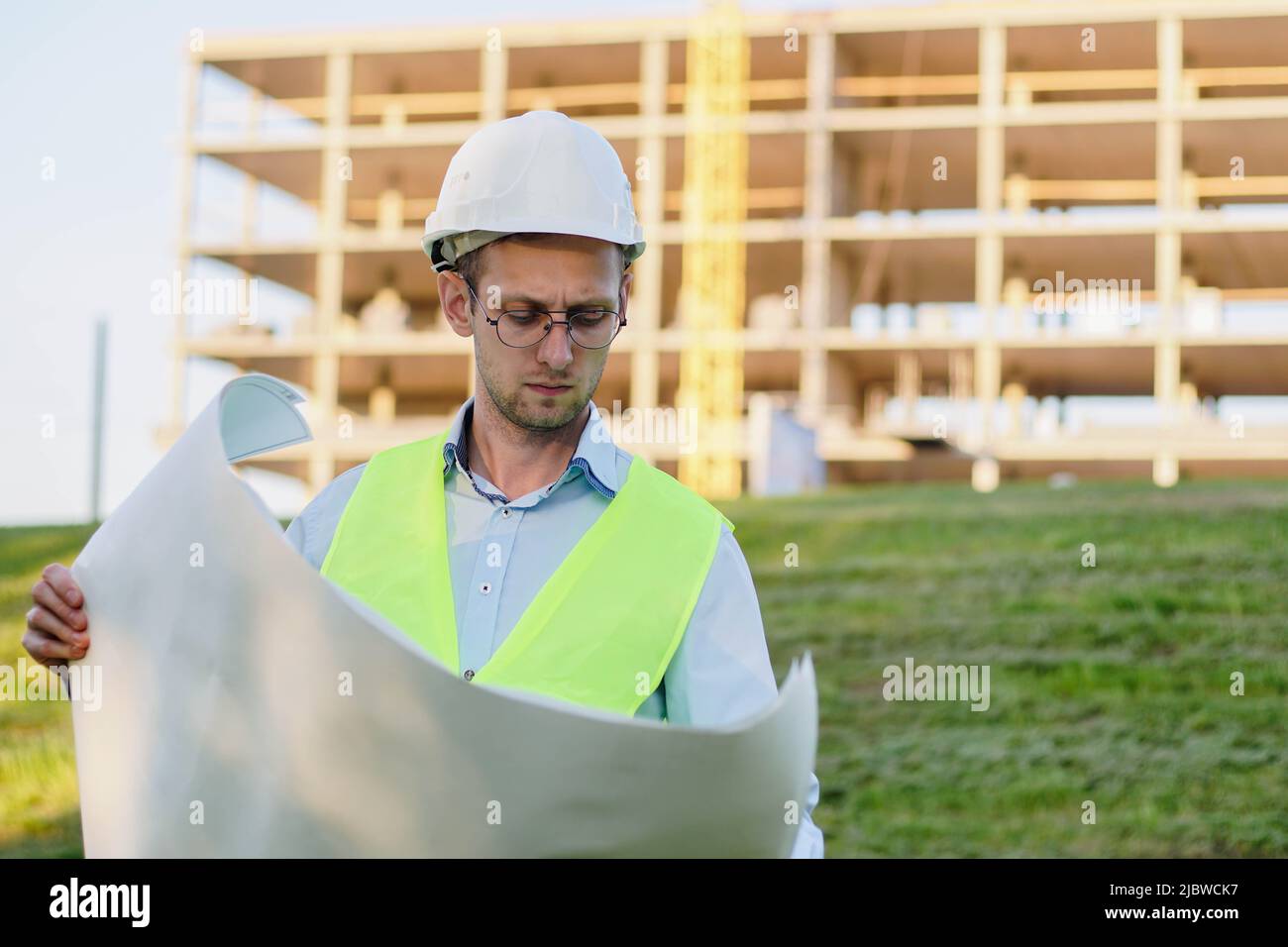 Civil Engineering wearing white helmet on construction site looking at ...