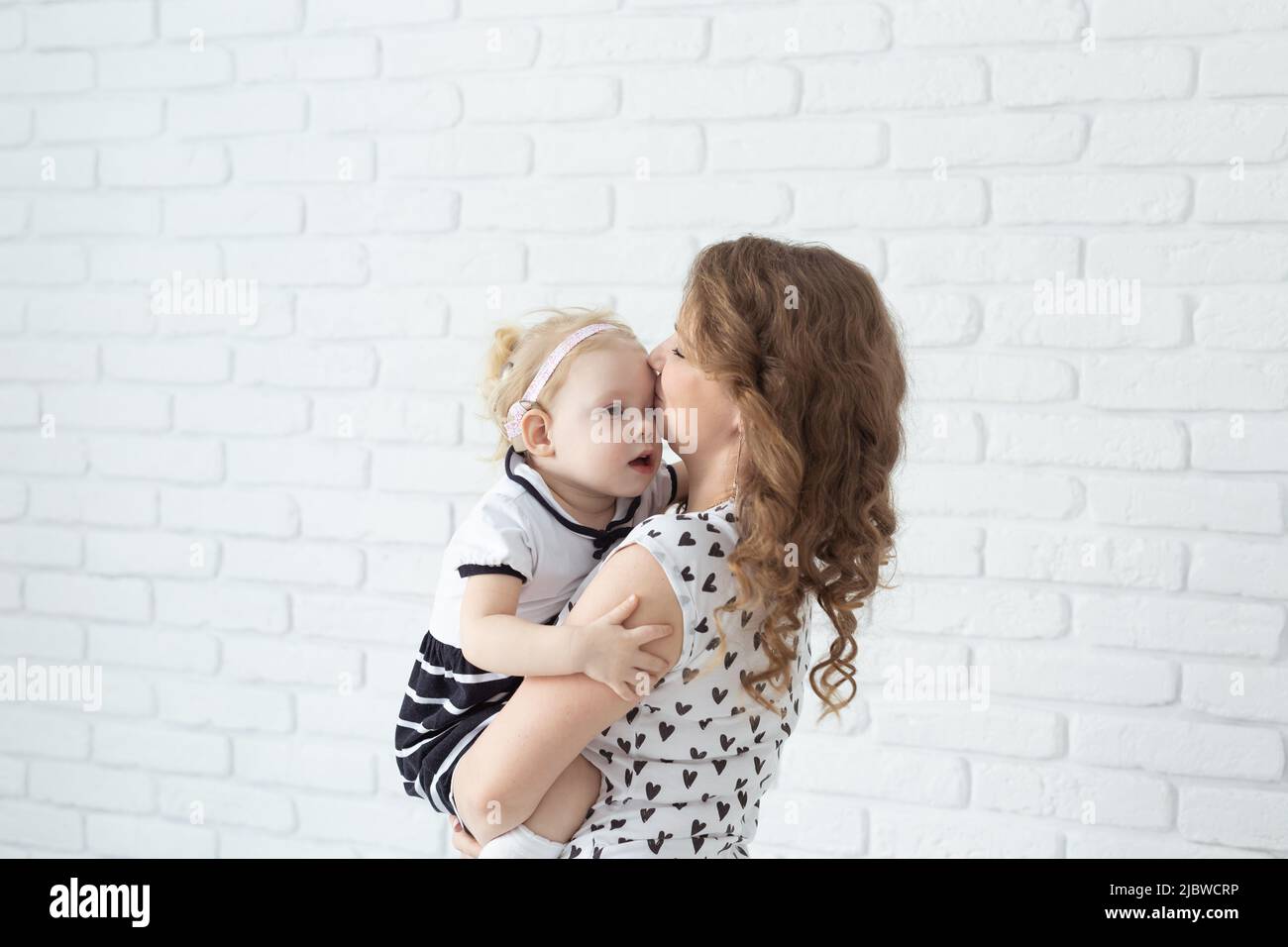 Mother holds and having fun child with hearing aids and cochlear ...