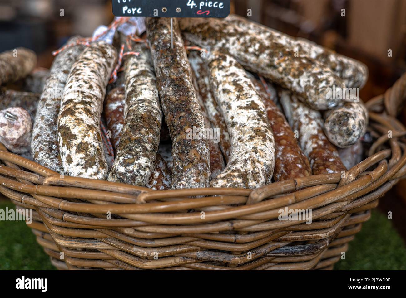 Stacks of dry-cured sausages - saucisson, typically made of pork, or a ...