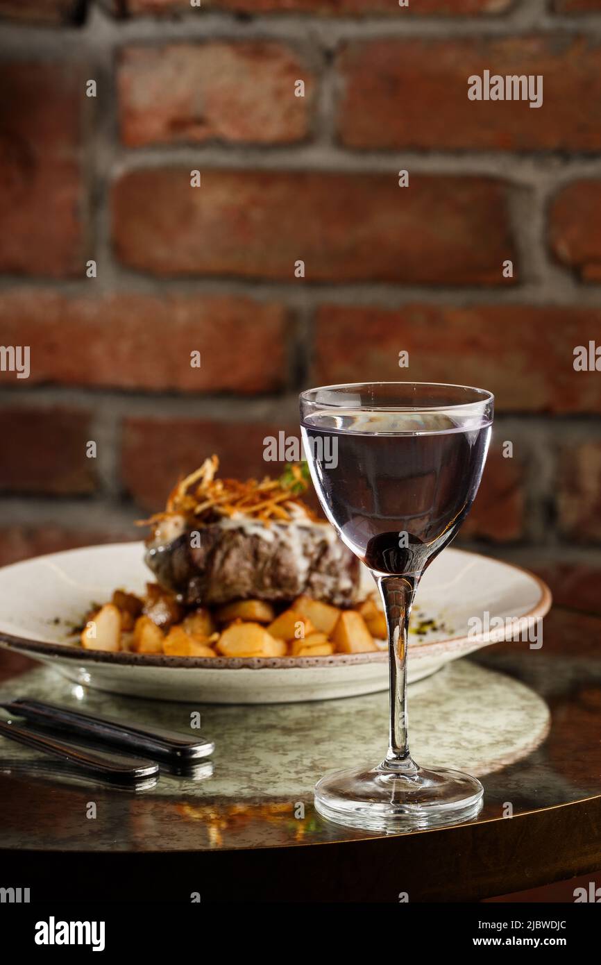 Grilled steak with baked golden potatoes served with crispy onion on ...
