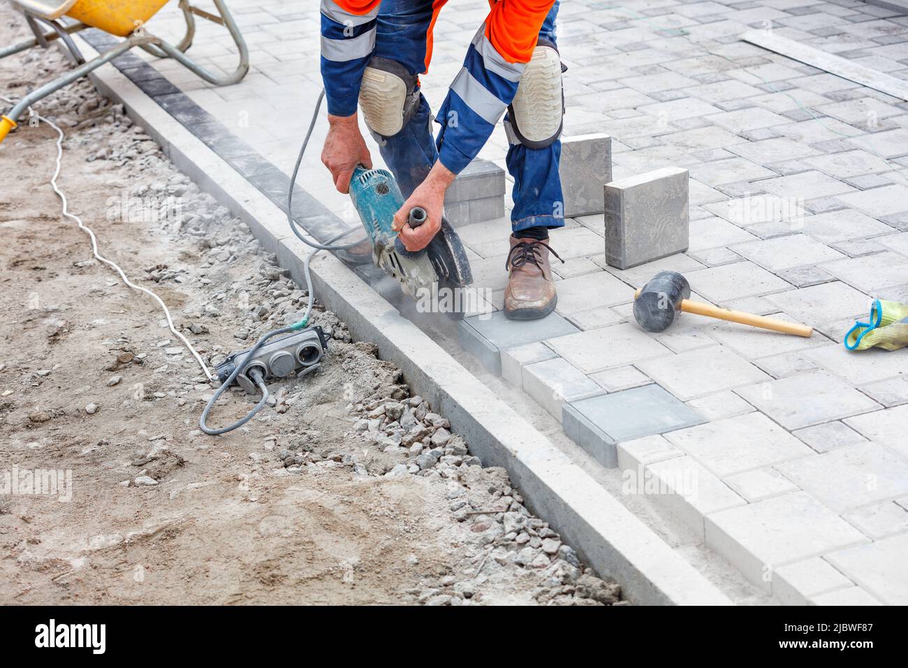 A construction worker using an electric grinder and a diamond cutting ...