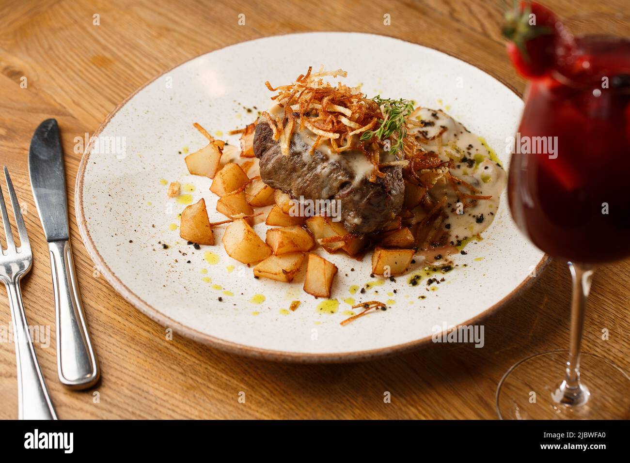 Grilled steak with baked golden potatoes served with crispy onion on ...
