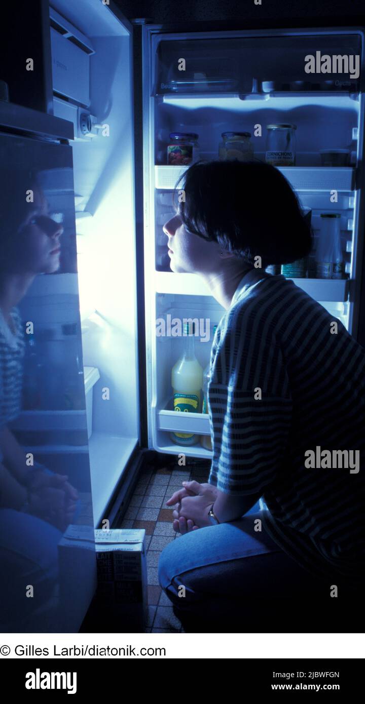 Girl looking into the fridge Stock Photo - Alamy