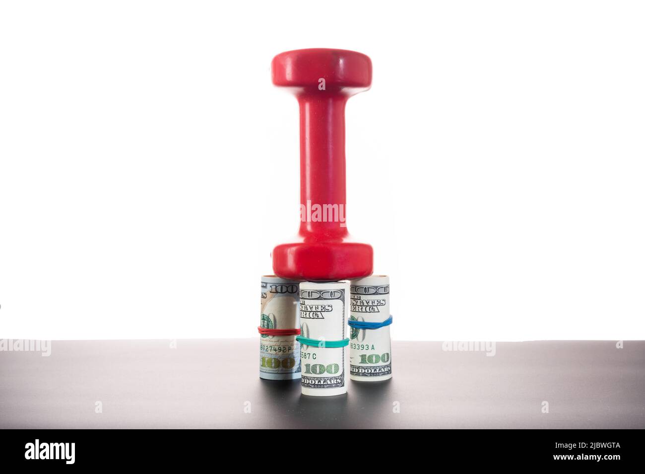 Red dumbbell standing on the money. Load bearing money. Money holding ...