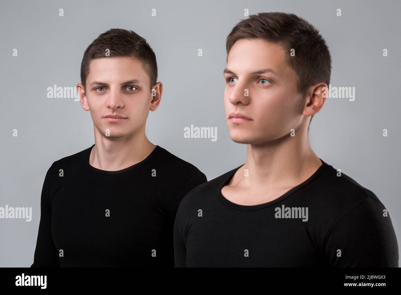 The two twin brother stand on the gray background Stock Photo - Alamy