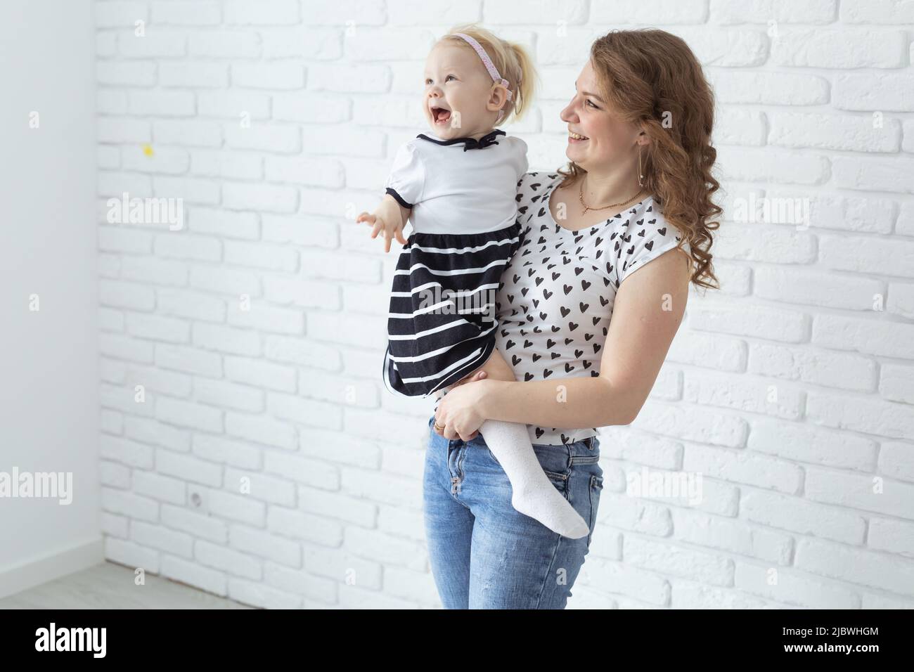 Mother holds and having fun child with hearing aids and cochlear ...