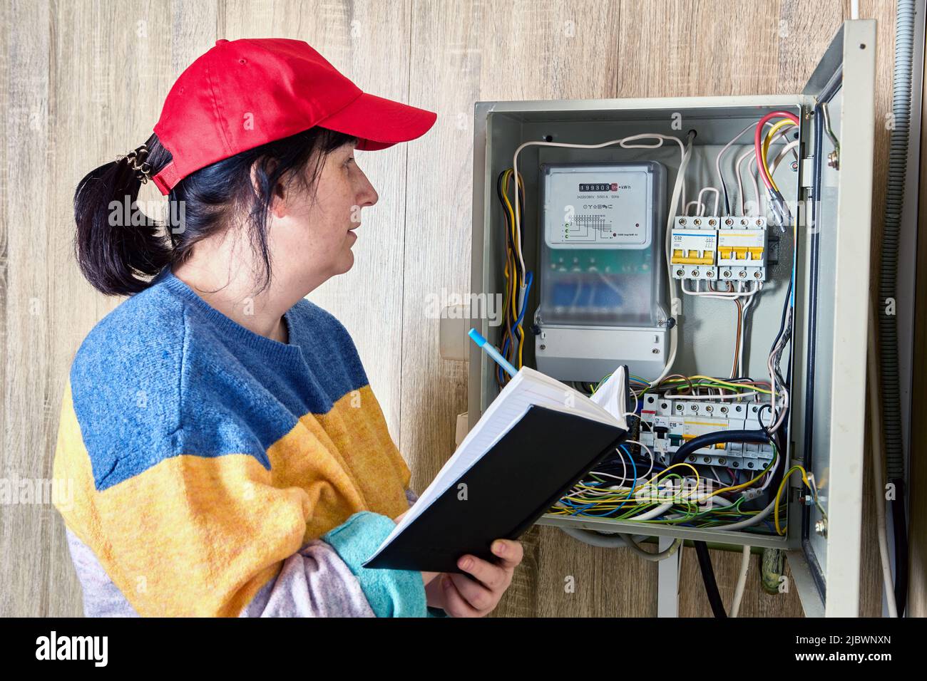 Taking readings from electricity meter by female electrician in ...