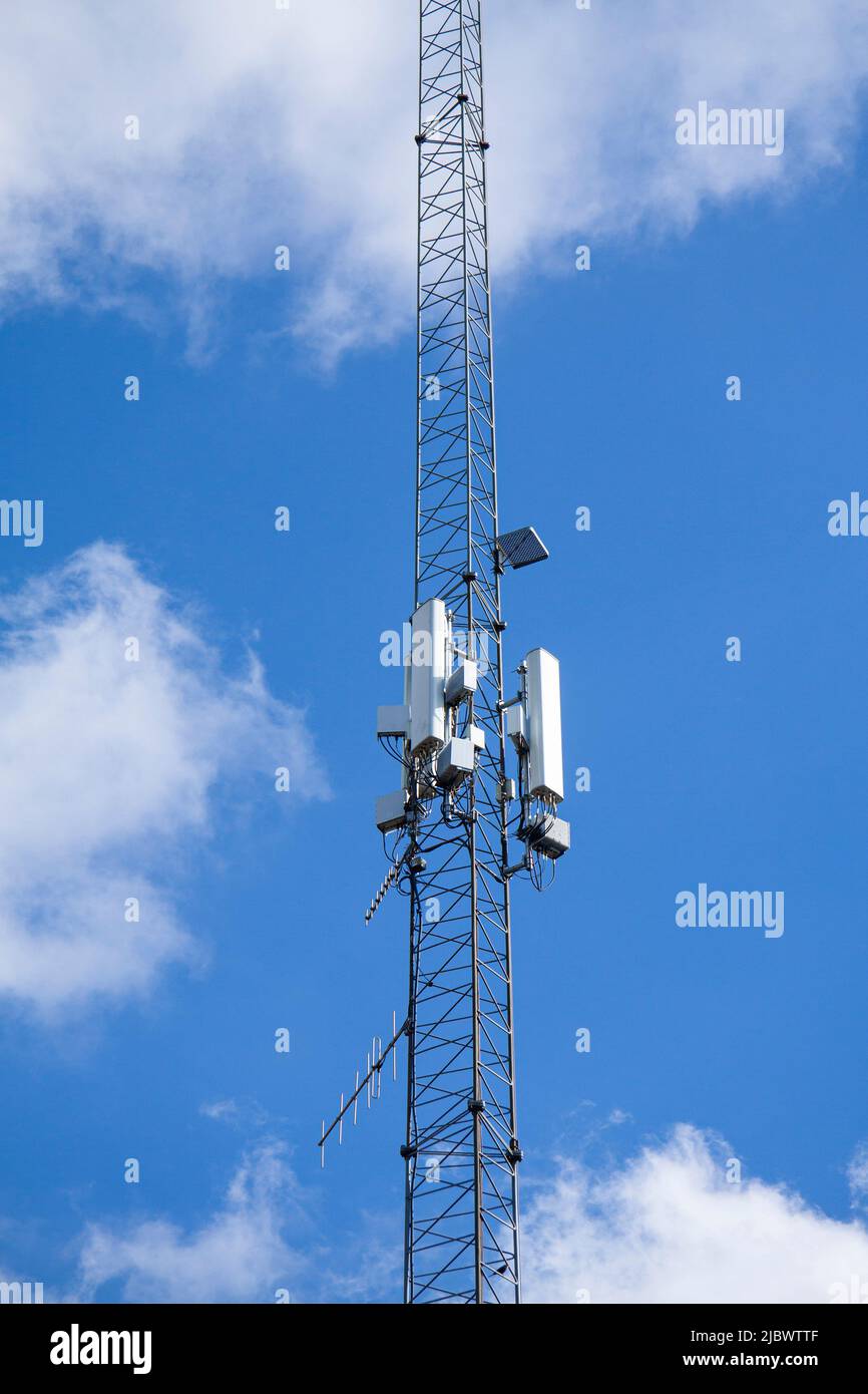 Cell tower, telecommunication mast against blue sky and white clouds ...
