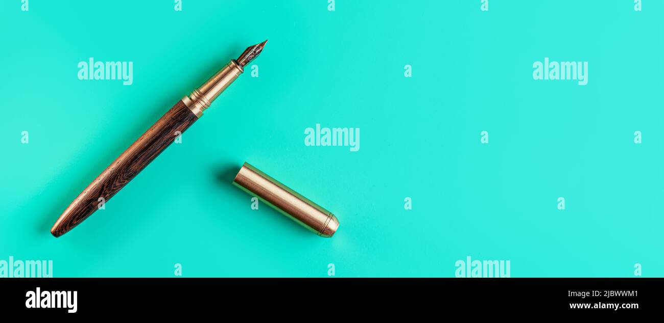 Wooden and gold fountain ink pen, opened, cap on the right, blue green ...